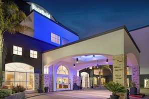 Um hotel com fachada moderna, ampla entrada em arco e uma placa com a inscrição 'Fairfield'.