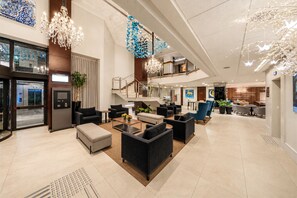 Um hall amplo com escada, área de estar e balcão de recepção.