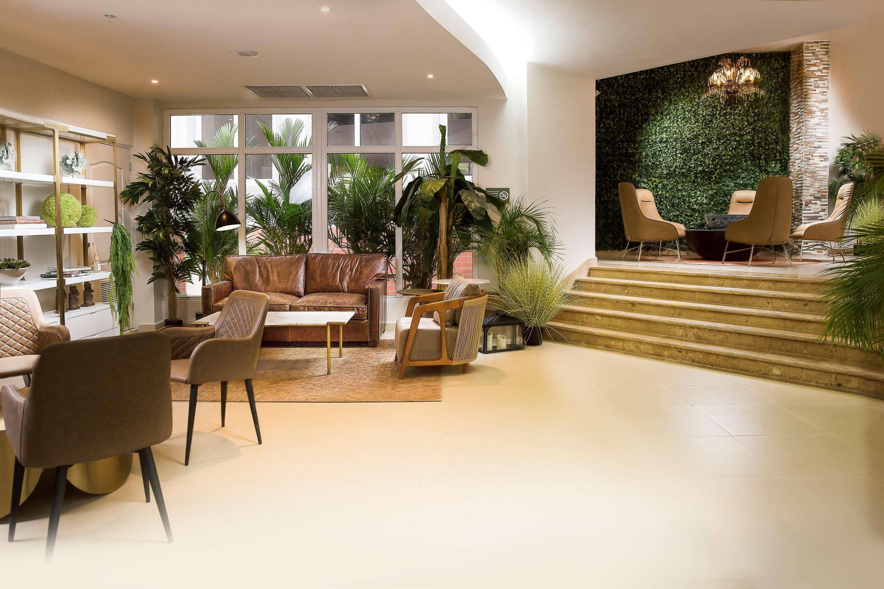 Uma sala de estar moderna com um sofá, cadeiras, uma mesa de centro e uma escada que leva a uma varanda com vista.