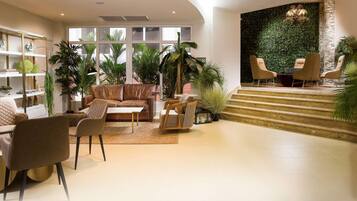 Uma sala de estar moderna com um sofá, cadeiras, uma mesa de centro e uma escada que leva a uma varanda com vista.