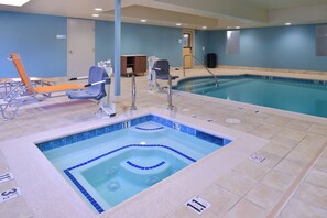 Piscina com hidromassagem, espreguiçadeiras e sala de trocas.