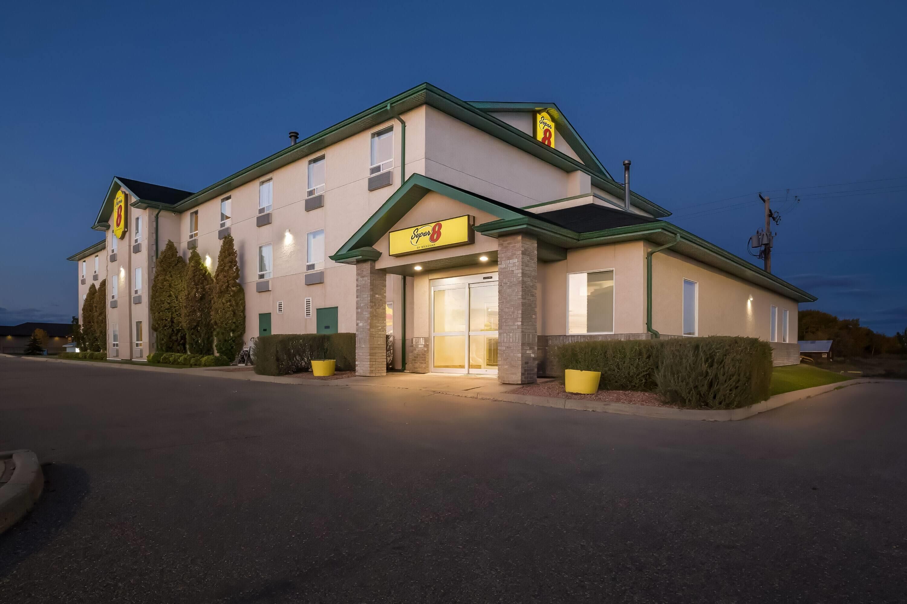 Um hotel com um letreiro grande com o número 8, várias janelas e uma entrada bem iluminada.