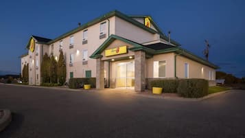 Um hotel com um letreiro grande com o número 8, várias janelas e uma entrada bem iluminada.