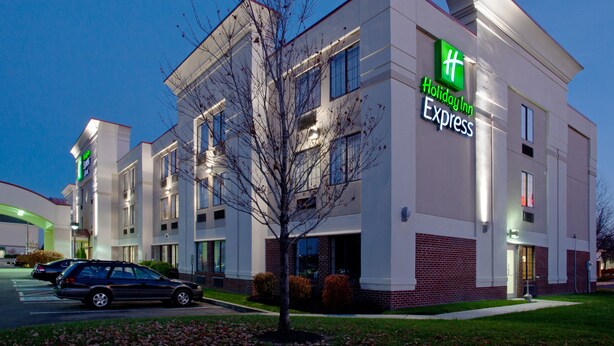Edifício Holiday Inn Express com design arquitetônico moderno, apresentando um telhado plano e janelas amplas.