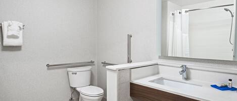 Uma casa de banho moderna com sanita, lavatório e chuveiro.