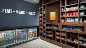 Uma área de exposição de lanches com bebidas refrigeradas e diversos snacks embalados.