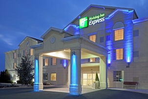 Edifício Holiday Inn Express com entrada coberta, grandes janelas e placa visível.