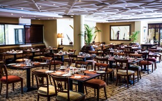 Uma ampla área de refeições com várias mesas e cadeiras, dispostas em estilo banquete.