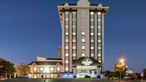 Um hotel alto com um destaque para a placa 'Country Inn & Suites', vários andares e um estacionamento na frente.