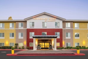 Um hotel com vários andares e uma entrada imponente, com a placa 'Towneplace Suites by Marriott'.