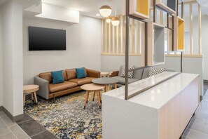 Uma sala de estar moderna com sofá, mesa de centro e TV na parede.