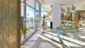 Um interior moderno com grandes janelas, uma mesa de vidro e móveis contemporâneos.