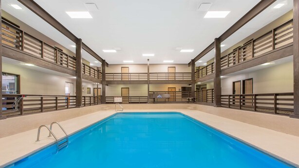 Uma piscina interior ampla com vários níveis de varandas e grades.