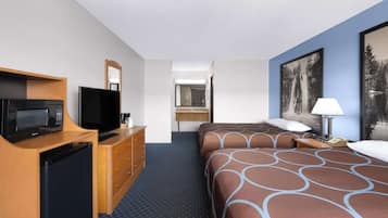 Quarto de hotel com cama, escrivaninha, televisão, micro-ondas e frigorífico.