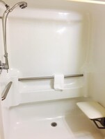 Uma combinação polibã/banheira, um secador de cabelo, roupões