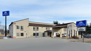 Um edifício de dois andares com estacionamento em frente, identificado como Americas Best Value Inn.