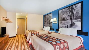Quarto de hotel com duas camas, televisão, escrivaninha e corredor que dá para outro quarto.