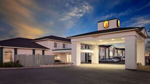 Um hotel Super 8 com entrada coberta e vários espaços de estacionamento.
