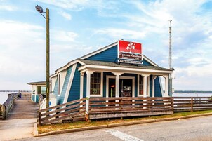 Um pequeno edifício térreo com fachada azul e uma placa que diz 'Cypress Landing State Park'.