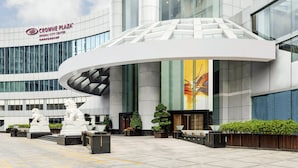 Um edifício moderno com entrada curva, uma estátua de leão e uma grande faixa vertical.