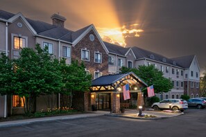Um hotel com fachada de pedra, várias janelas e uma bandeira americana.