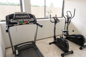Uma academia em casa com esteira ProForm, elíptica e bicicleta ergométrica.