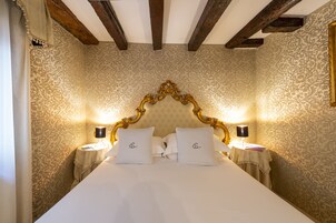 Quarto com uma cama grande, cabeceira elaborada e duas luminárias de cabeceira.