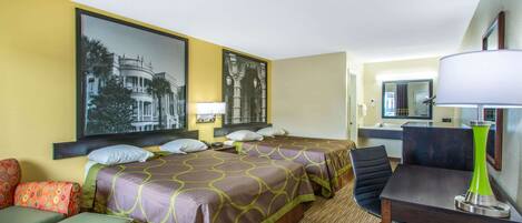 Quarto de hotel com duas camas, uma escrivaninha, uma cadeira e um espelho grande.