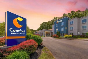 Placa do Comfort Inn & Suites com um edifício moderno ao fundo.
