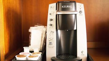 Uma cafeteira Keurig com manual e cápsulas de café.