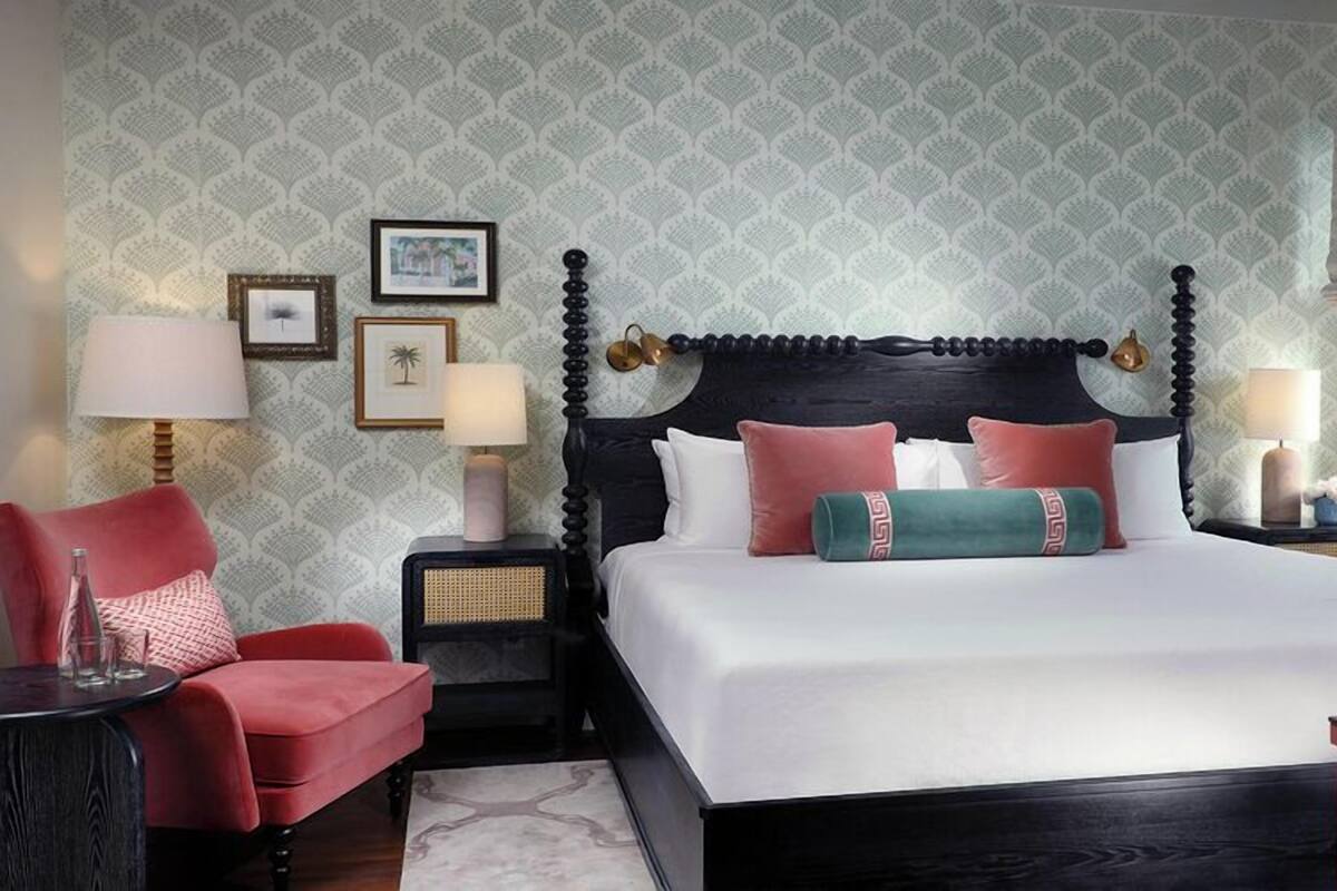 Quarto com cama, mesas de cabeceira, uma cadeira e cômoda.