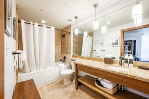 Uma casa de banho moderna com banheira, sanita e lavatório.