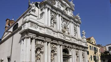 Um edifício histórico com detalhes arquitetônicos elaborados, incluindo colunas e estátuas.