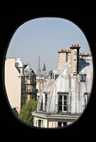Vista de prédios parisienses com a Torre Eiffel ao fundo.