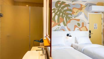 Quarto de hotel com banheiro, uma cama e chuveiro.