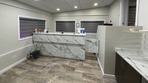 Cozinha moderna com bancadas de mármore, uma ilha central e luminárias embutidas no teto.