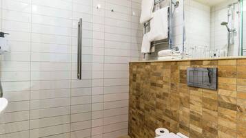 Uma casa de banho moderna com chuveiro, sanita e lavatório.