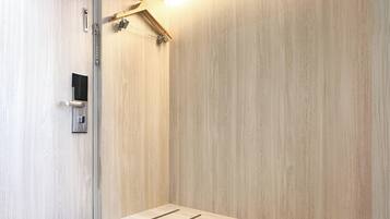 Uma casa de banho moderna e minimalista com um lavatório de madeira, um porta-toalhas e um chuveiro integrado.