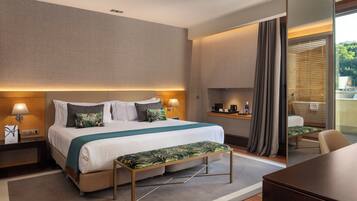 Quarto de hotel moderno com uma cama grande, luminárias de cabeceira, um banco e uma escrivaninha.