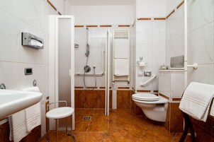 Casa de banho com chuveiro, sanita, lavatório e um porta-toalhas.