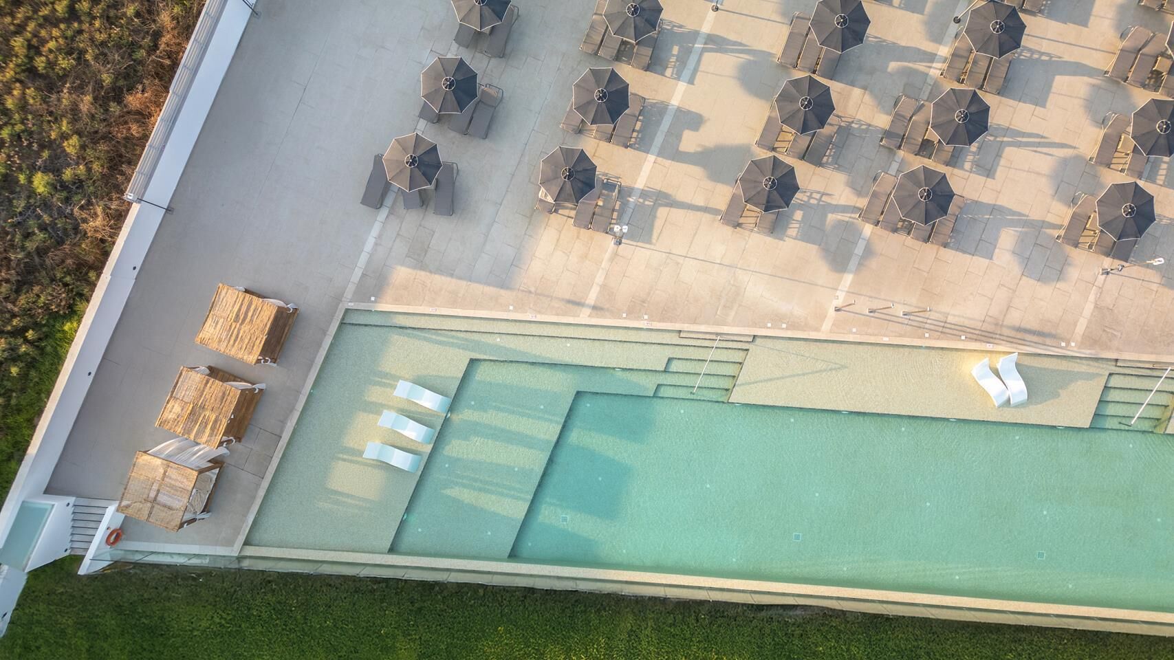 Vista aérea de um hotel com área externa para refeições e piscina.