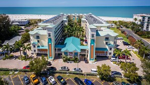 Um hotel com um pátio central, vários andares e vista para a praia.