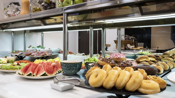 Buffet com diversos alimentos, incluindo frutas, legumes e doces.