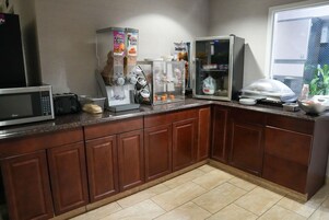 Cozinha equipada com micro-ondas, torradeira, máquina de café e frigorífico.