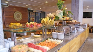 Um buffet com diversas frutas, legumes e pratos prontos.