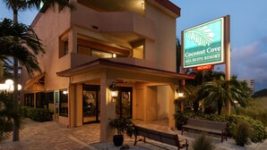 Um resort com uma placa indicando 'Coconut Cove All-Suite Resort' e 'Sem quartos disponíveis'.