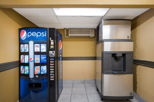 Máquina de vendas automática e bebedouro em um corredor.