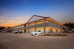 Um hotel com vários andares, teto plano e estacionamento.