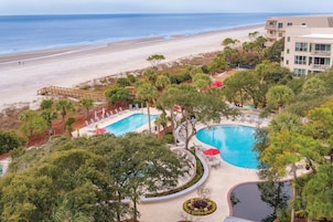 Um resort com piscina, vista para a praia e vários edifícios.