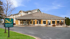 Uma Quality Inn & Suites com design moderno, destacando uma entrada ampla e um gramado bem cuidado.